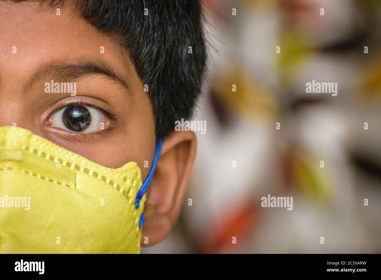 Isolated young Indian boy with prominent eyes wearing N95 face mask for ...