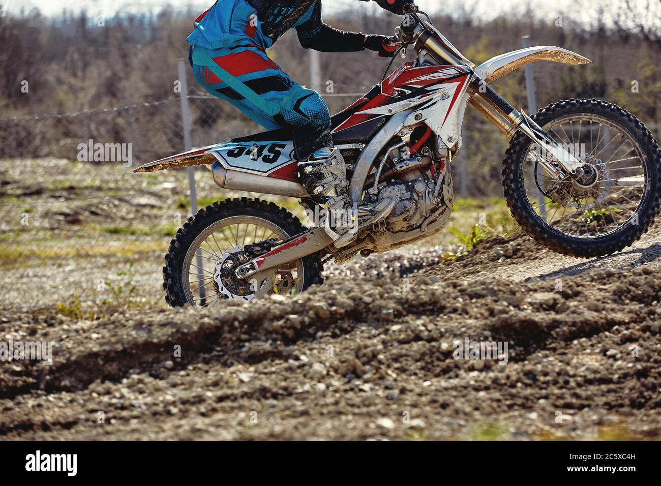 Motocross driver in action accelerating the motorbike takes off and ...