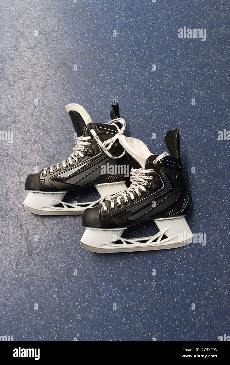 Hockey skates over floor in locker room with blue background and copy ...