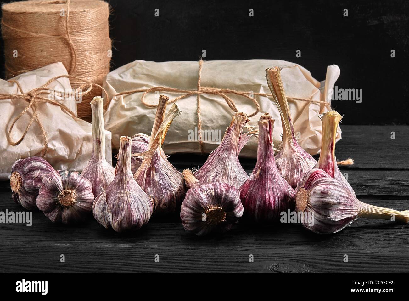 Food photo of red garlic on dark wooden background, side view. Organic ...