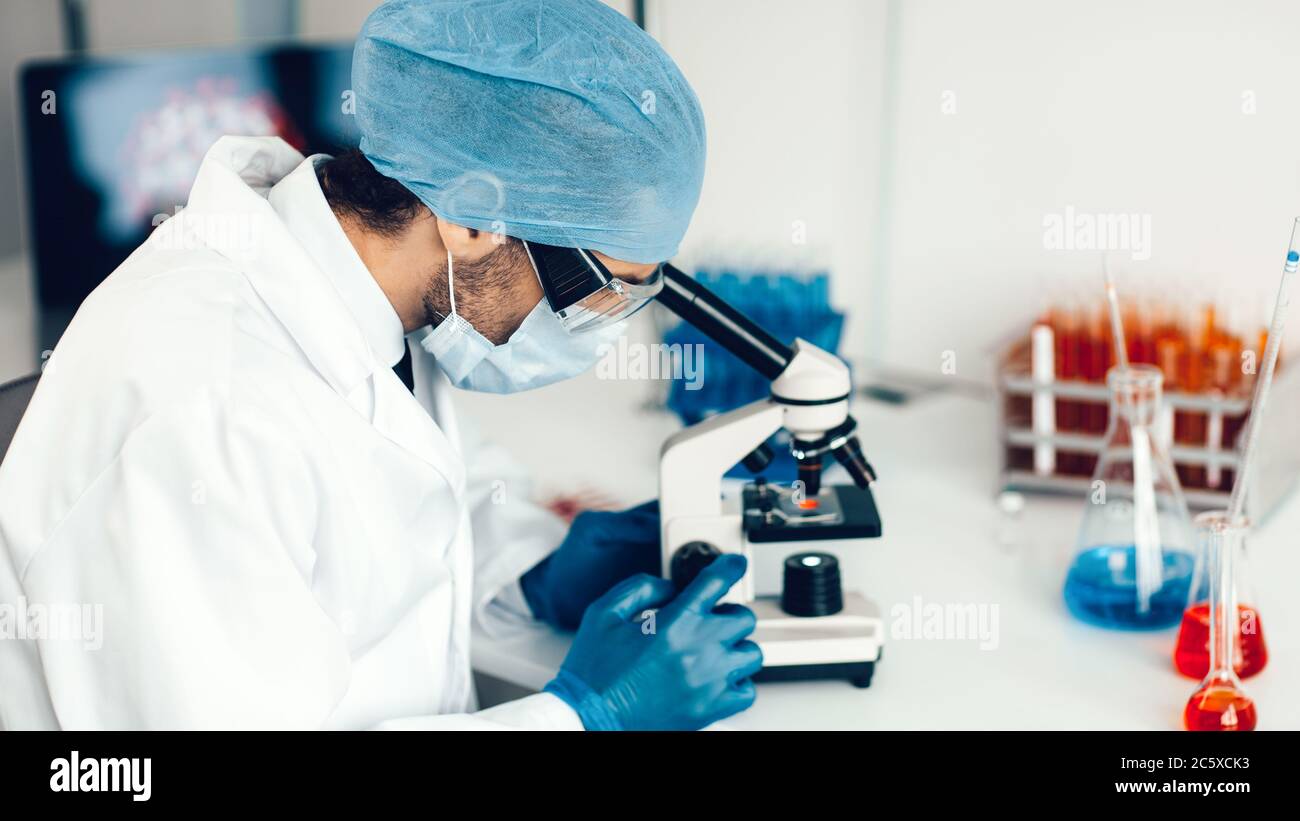 scientist looking at a drop of blood through a microscope Stock Photo ...