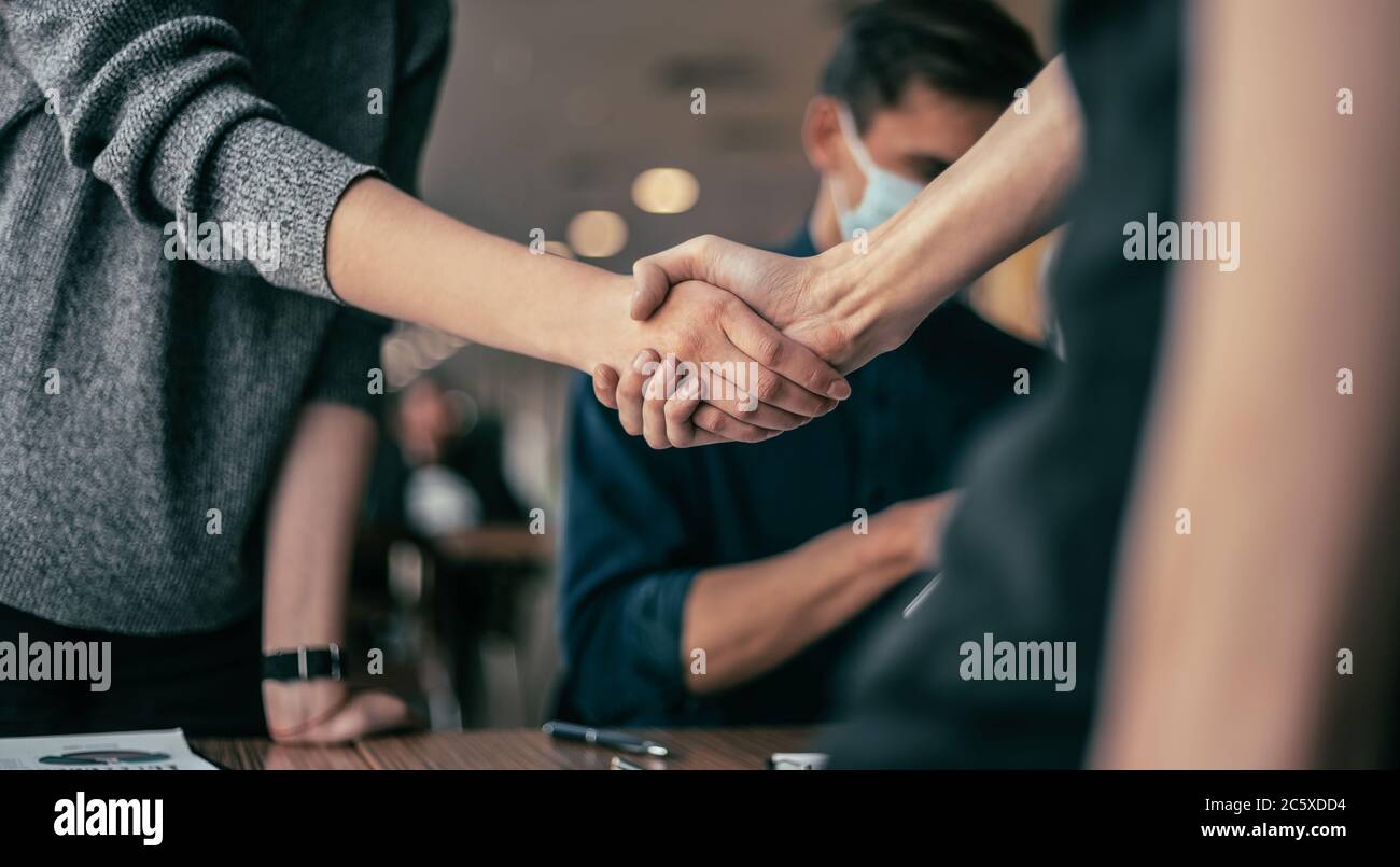 young people shaking hands in the office Stock Photo - Alamy