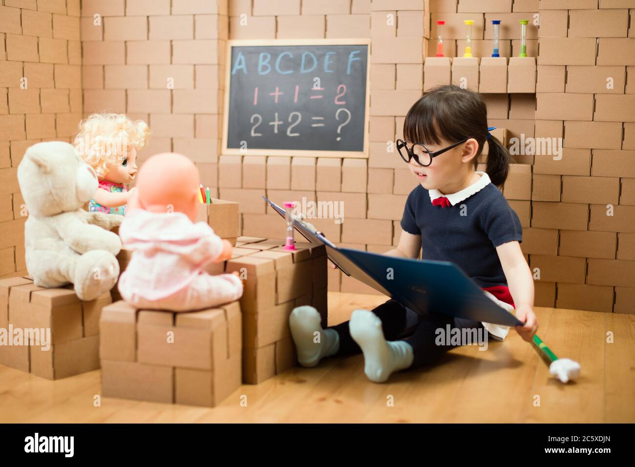 toddler girl pretend play as a teacher at home Stock Photo - Alamy