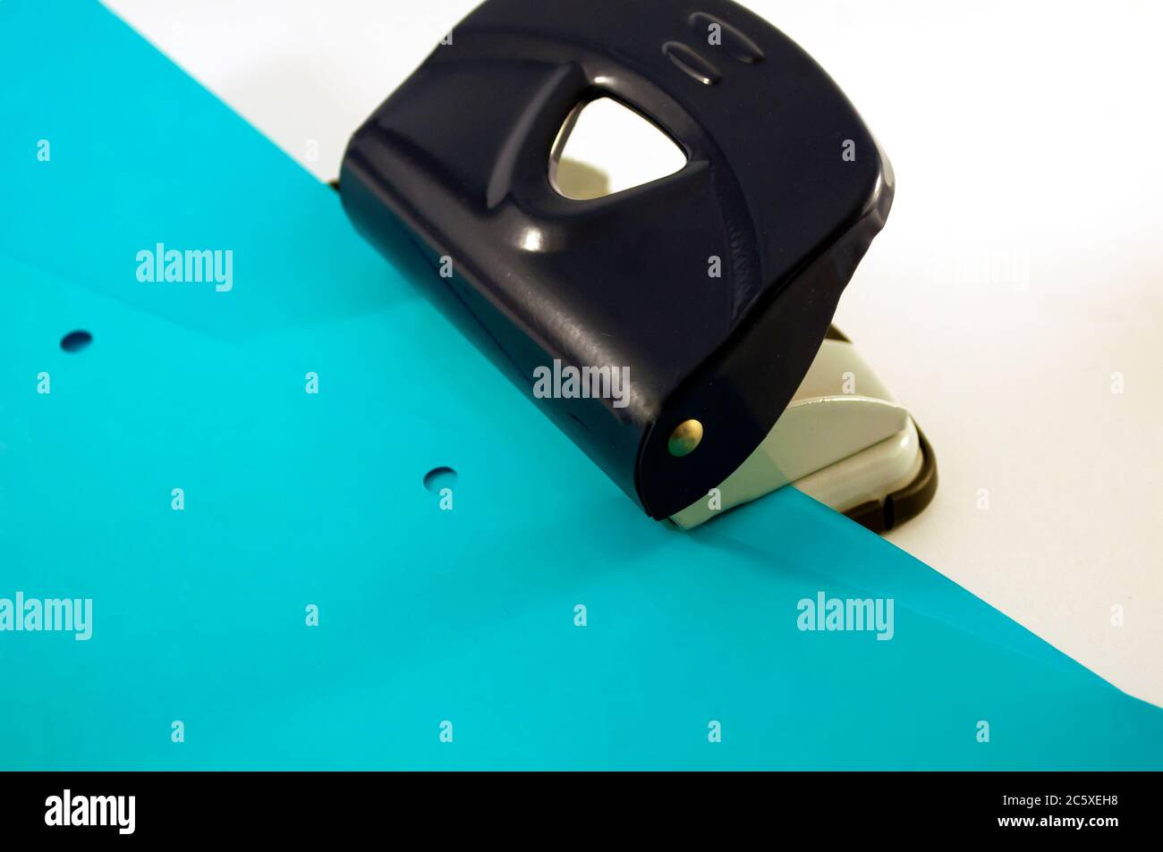 office: punch, blue paper with punch holes on a white background with ...