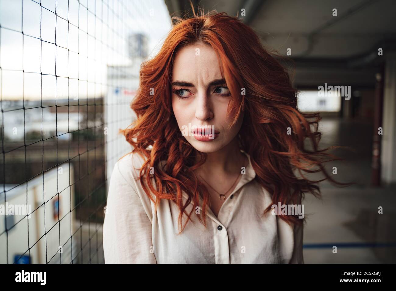 Portrait of frowning caucasian girl with long elegant red hairs ...
