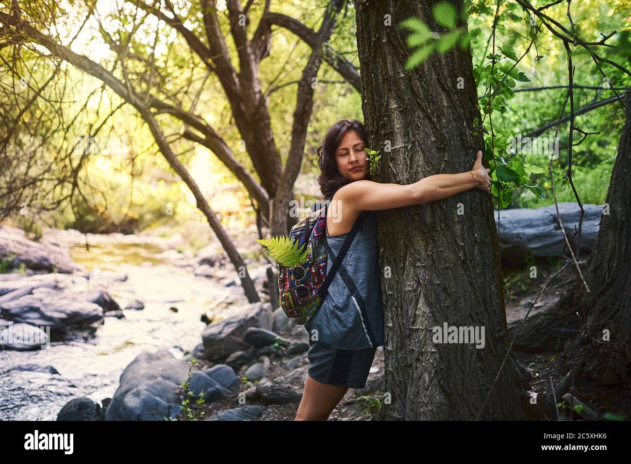 Young woman hugging a tree. She is happy Stock Photo - Alamy