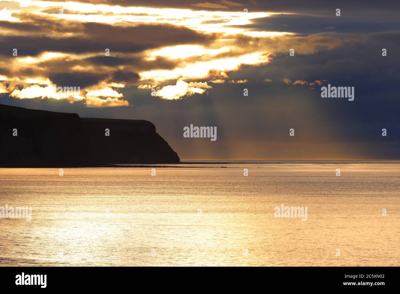 The sun begins to set behind a cloudy sky in Whitby,North Yorkshire ...