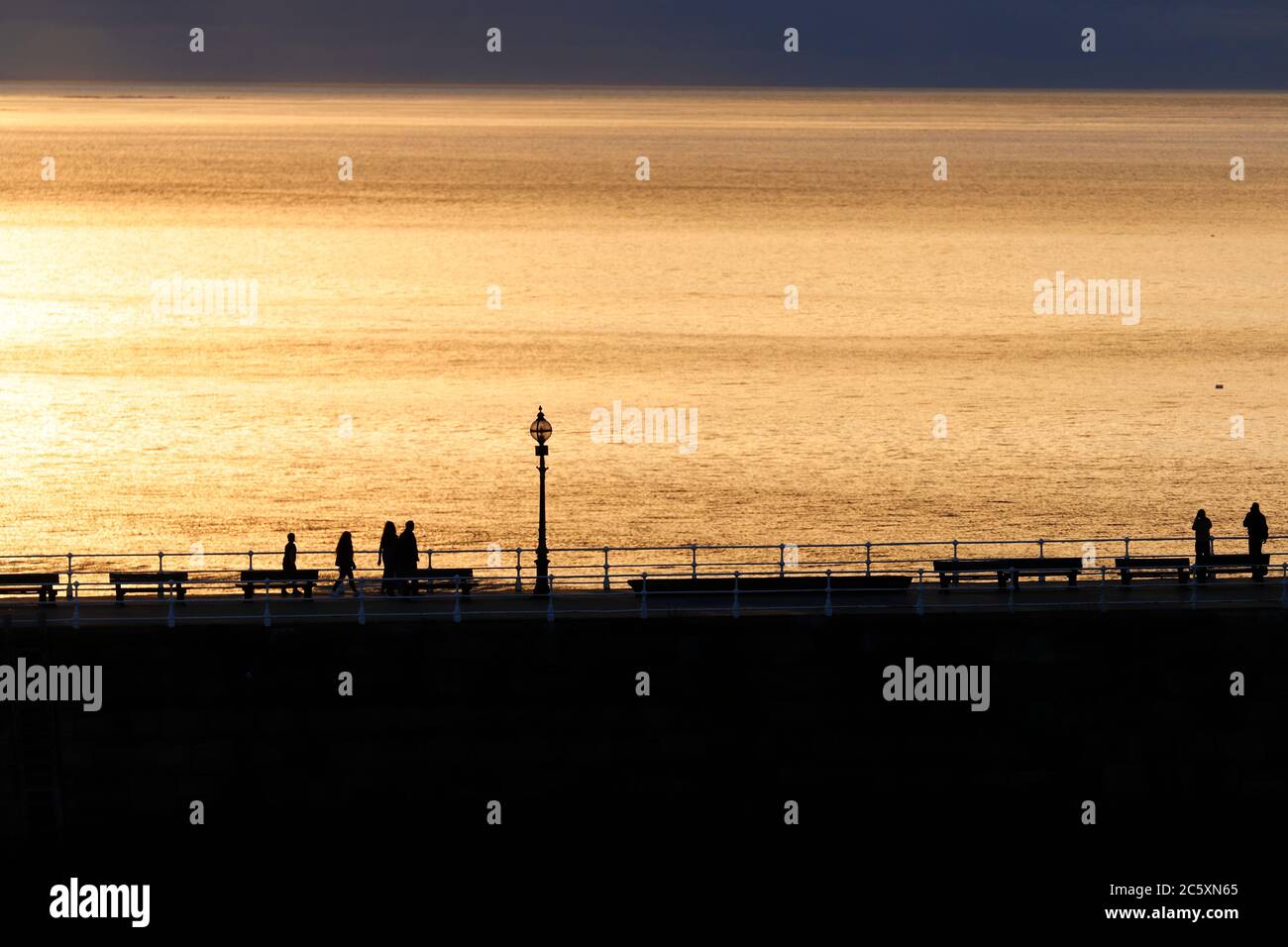 Sunset over Whitby Pier in North Yorkshire Stock Photo - Alamy
