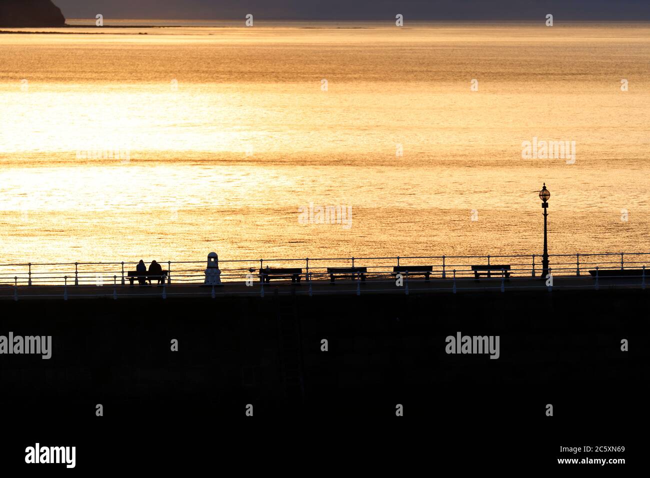 Sunset over Whitby Pier in North Yorkshire Stock Photo - Alamy