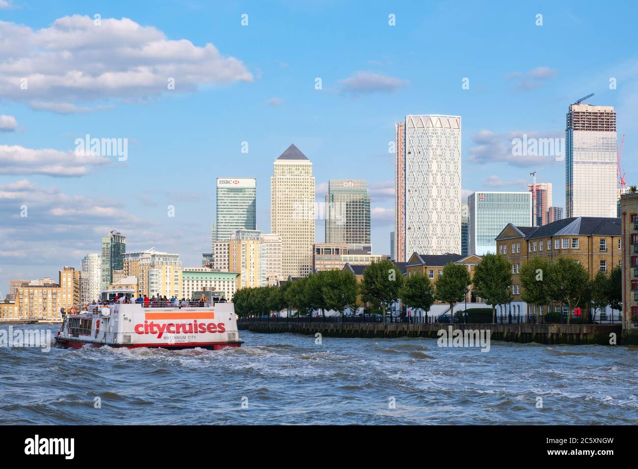 Ferry on the river Thames in London with a view of Canary Wharf on the ...