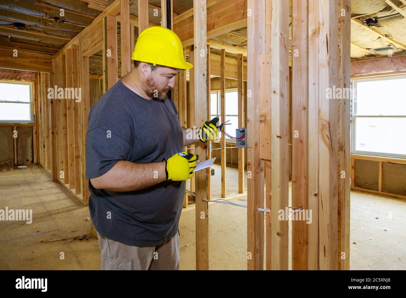 House under construction a inspector man inspects house electrical ...