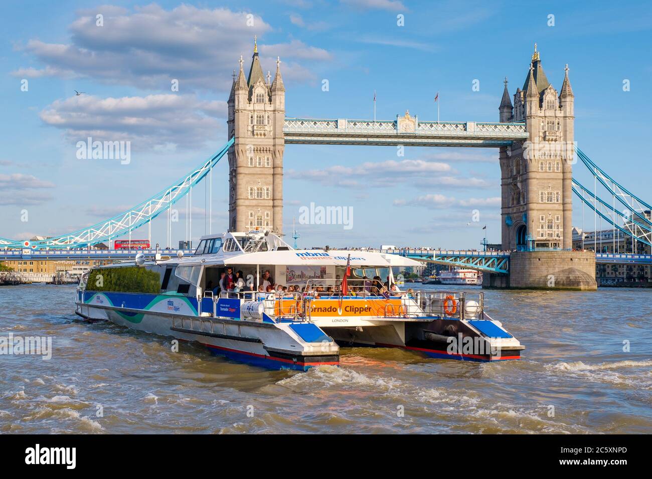 Thames Clipper catamaran next to the Tower Bridge on the river Thames ...