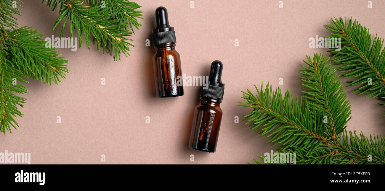 Glass dropper bottles of conifer essential oils on beige background ...