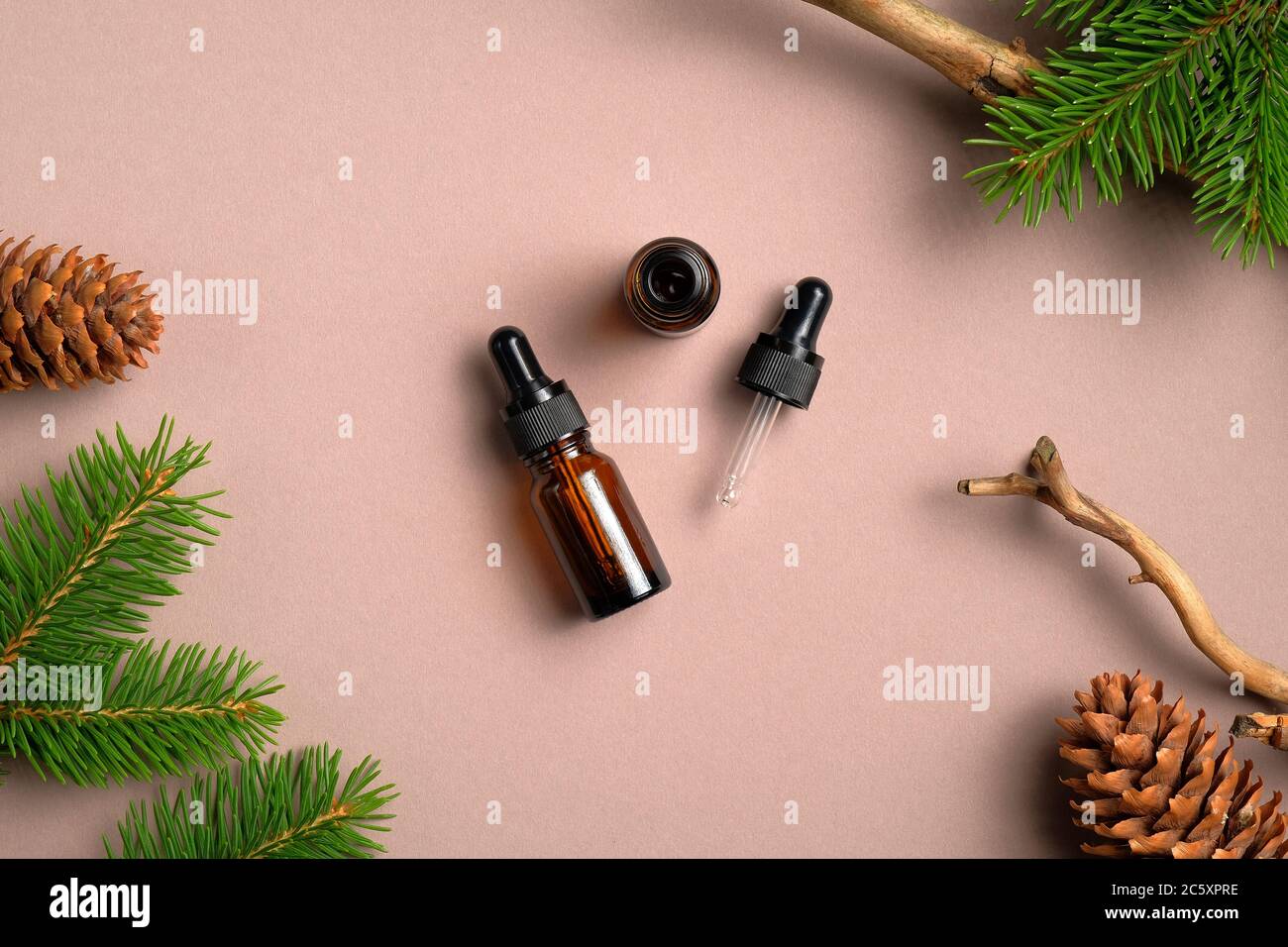 Flat lay composition with bottles of conifer essential oil on beige ...