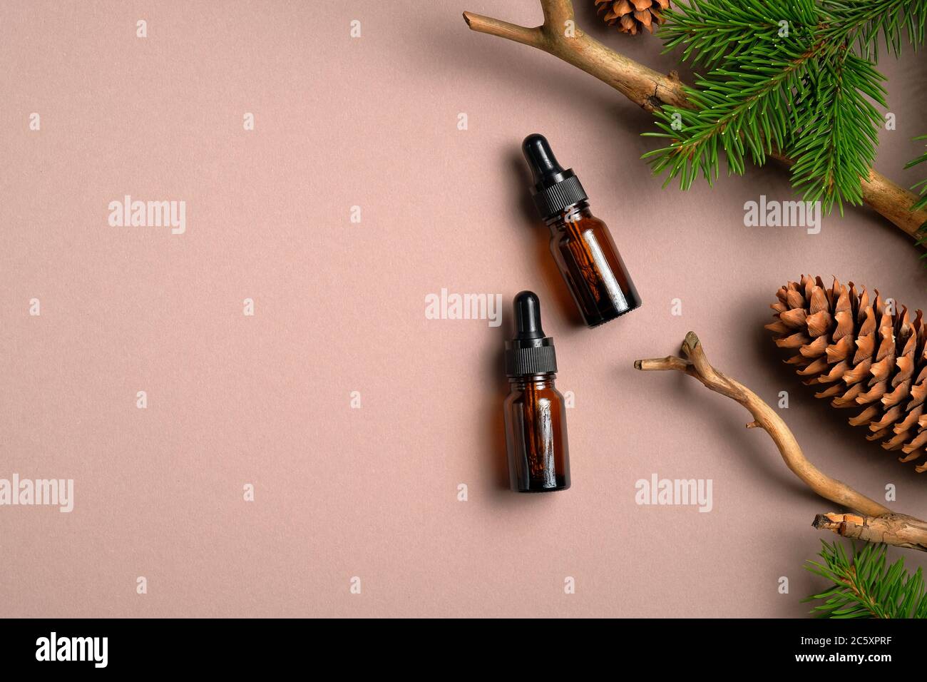 Flat lay composition with bottles of conifer essential oil on beige ...
