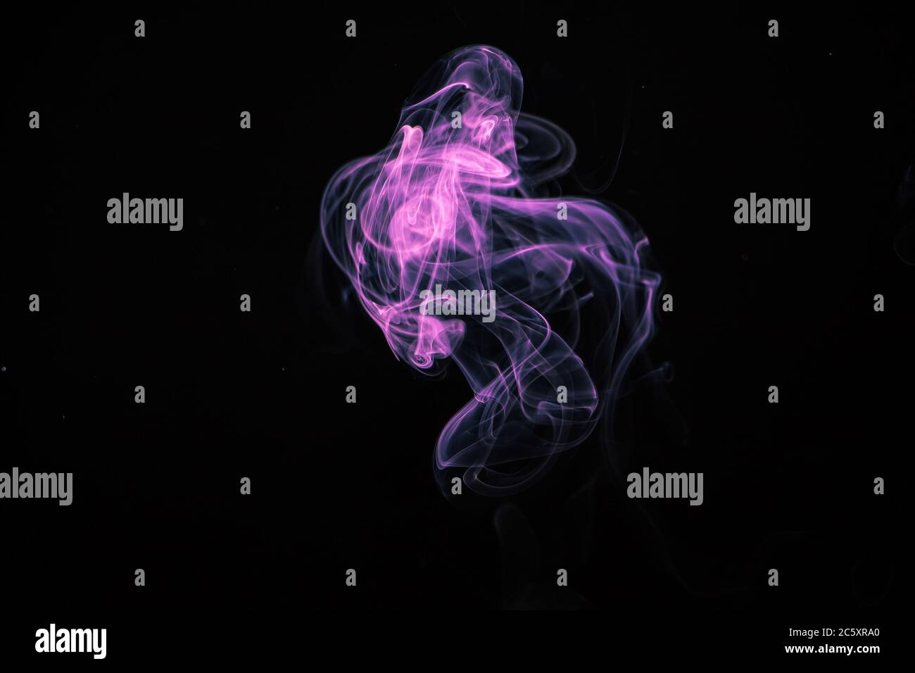 Unusual purple smoke on a black background Stock Photo - Alamy