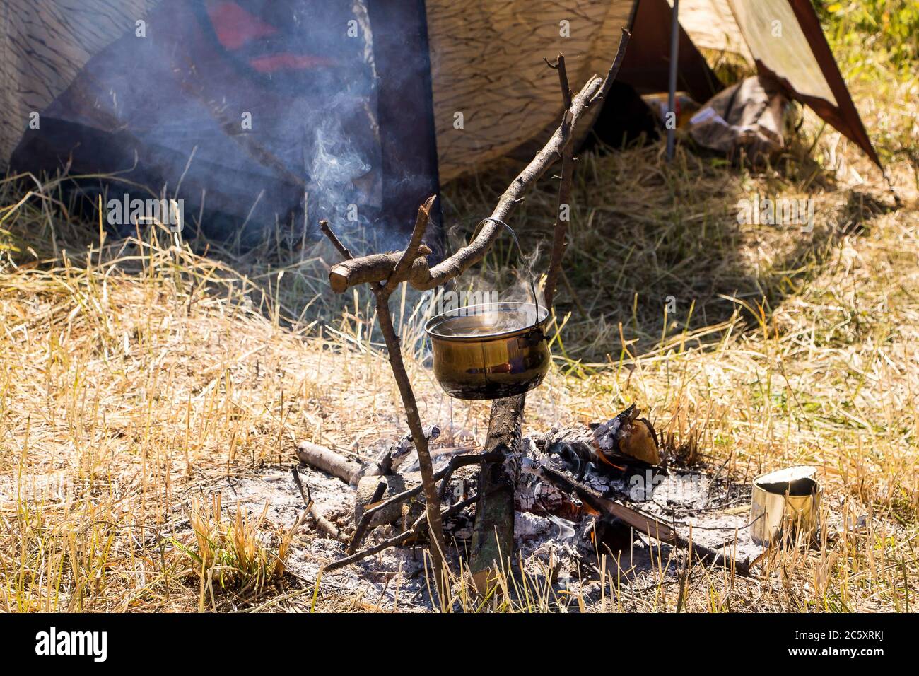 Camping outdoors - tents, equipment and cooking. Cooking at a camping ...