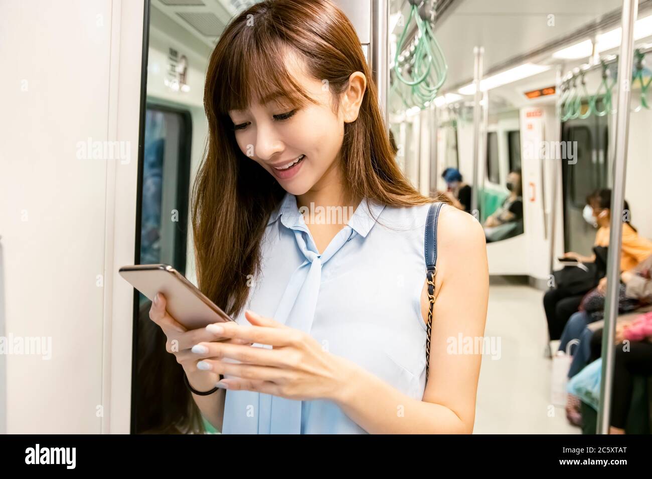 young woman watching the mobile phone in subway train Stock Photo - Alamy