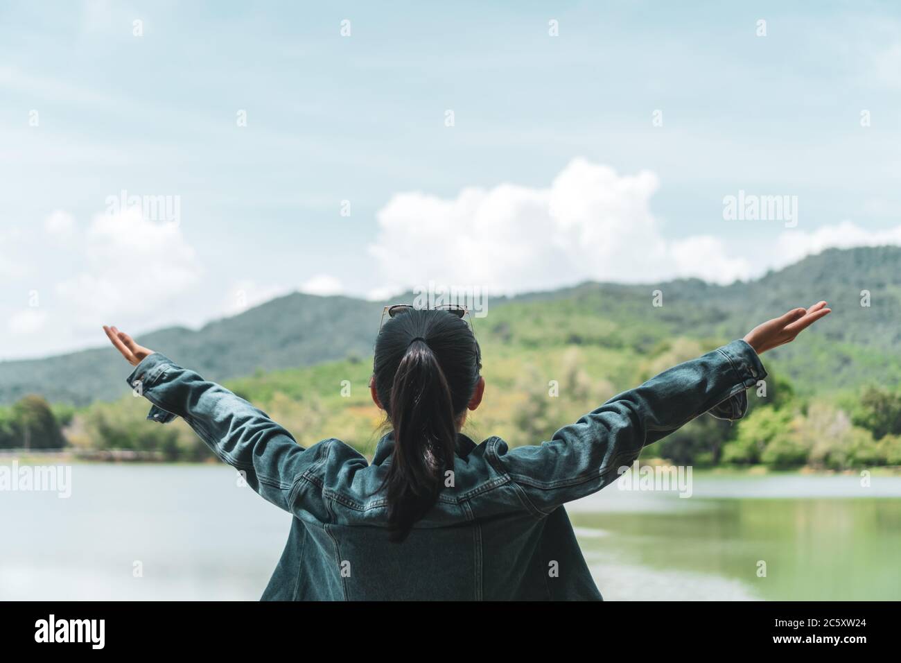 Woman rise hands up to sky freedom concept with blue sky and summer ...