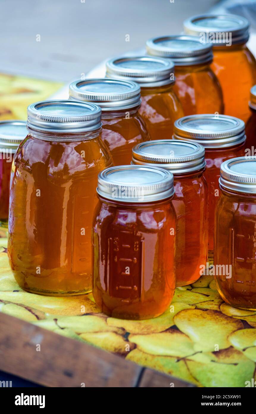 Jars of golden honey make a delicious display at this local farmers ...