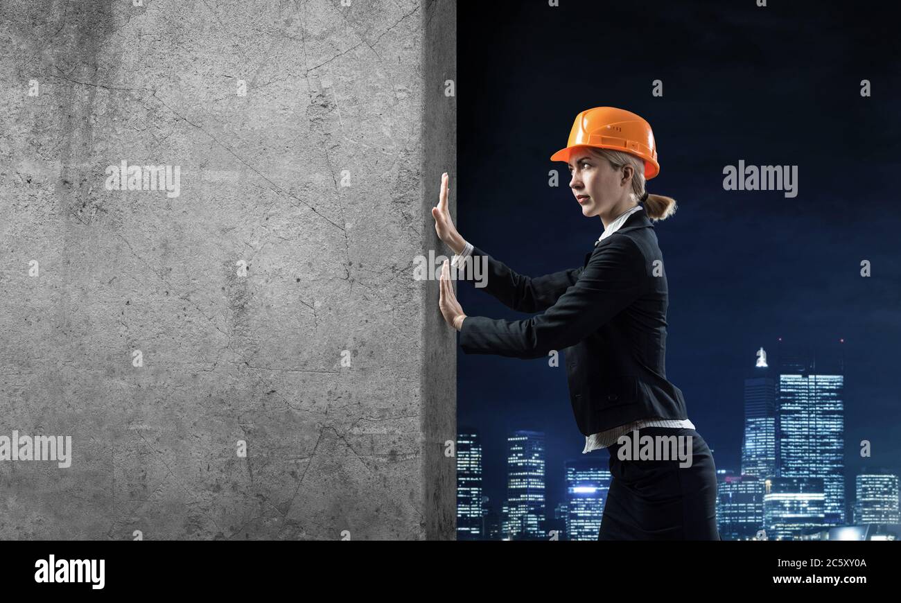 Beautiful woman architect pushing concrete wall Stock Photo - Alamy
