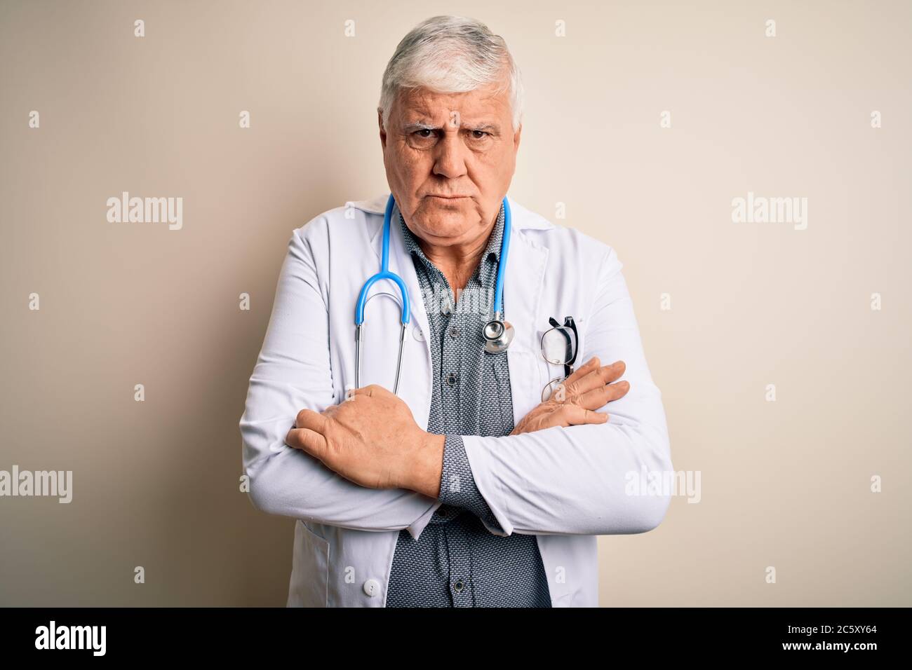 Senior handsome hoary doctor man wearing coat and stethoscope over ...