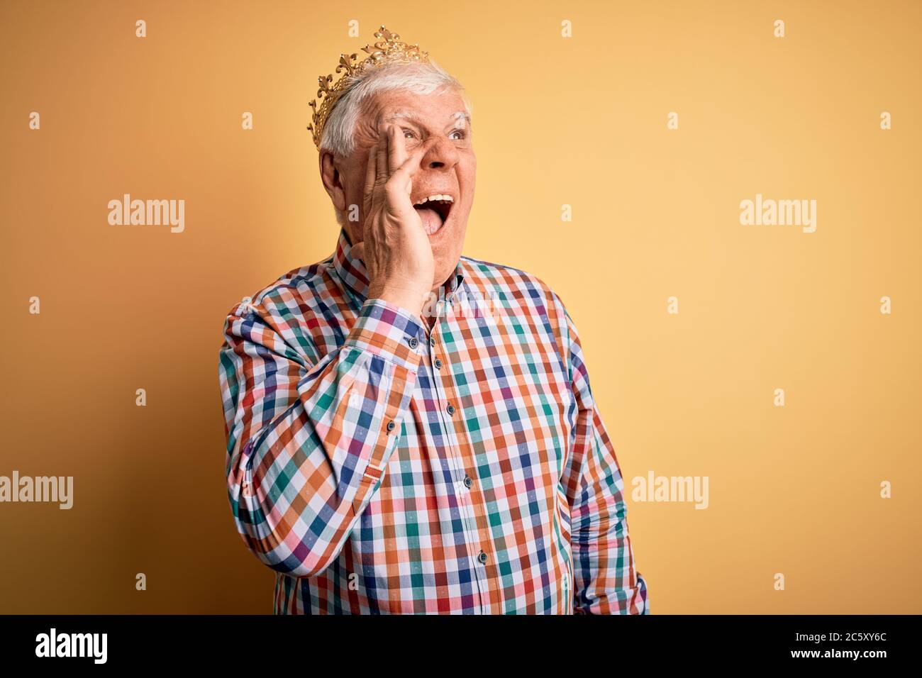 Senior handsome hoary man wearing golden crown of king over isolated ...