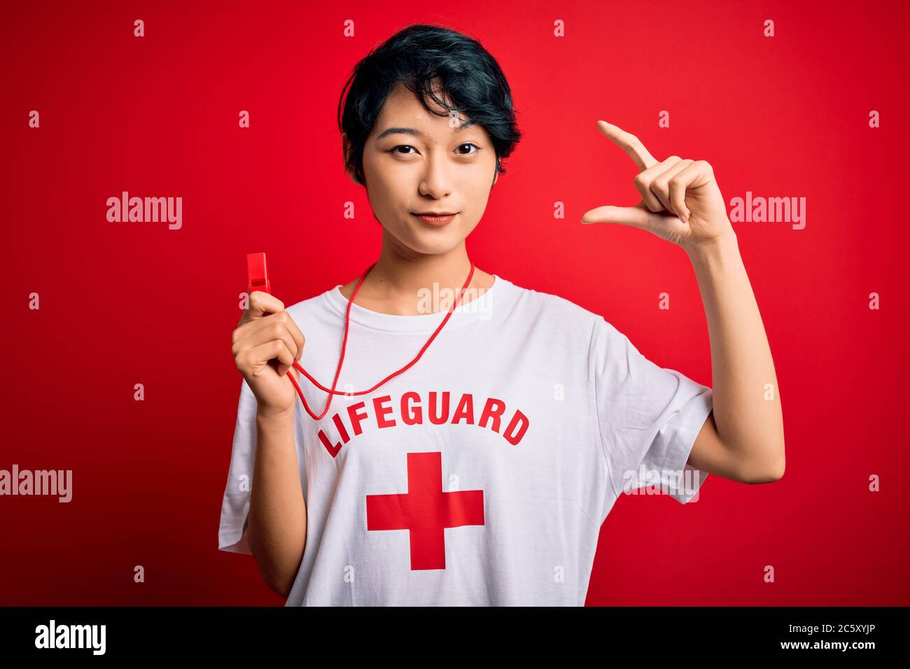 Young beautiful asian lifeguard girl wearing t-shirt with red cross ...