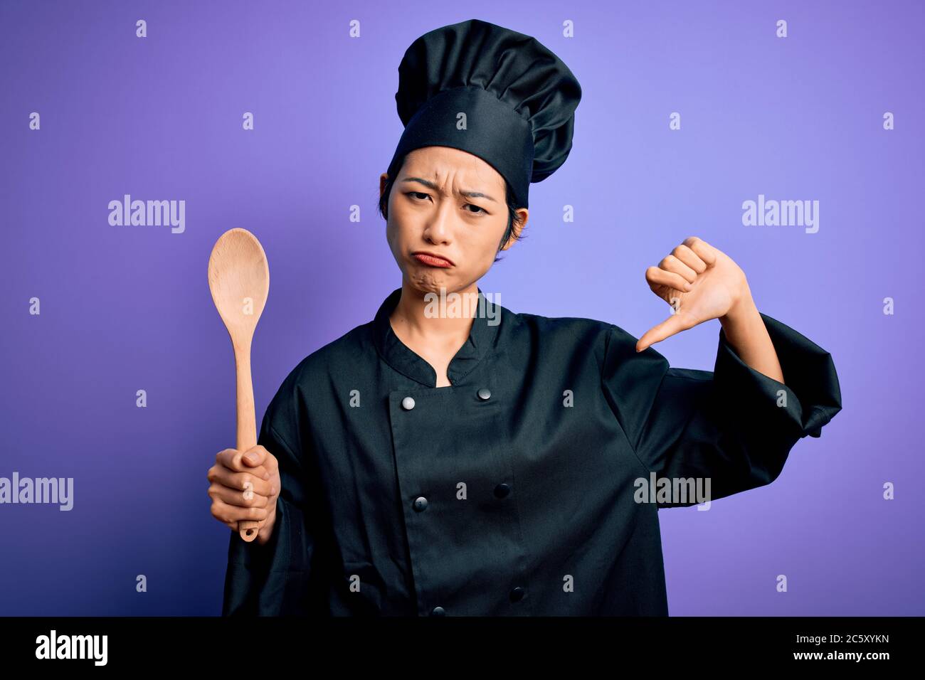 Young beautiful chinese chef woman wearing cooker uniform and hat ...