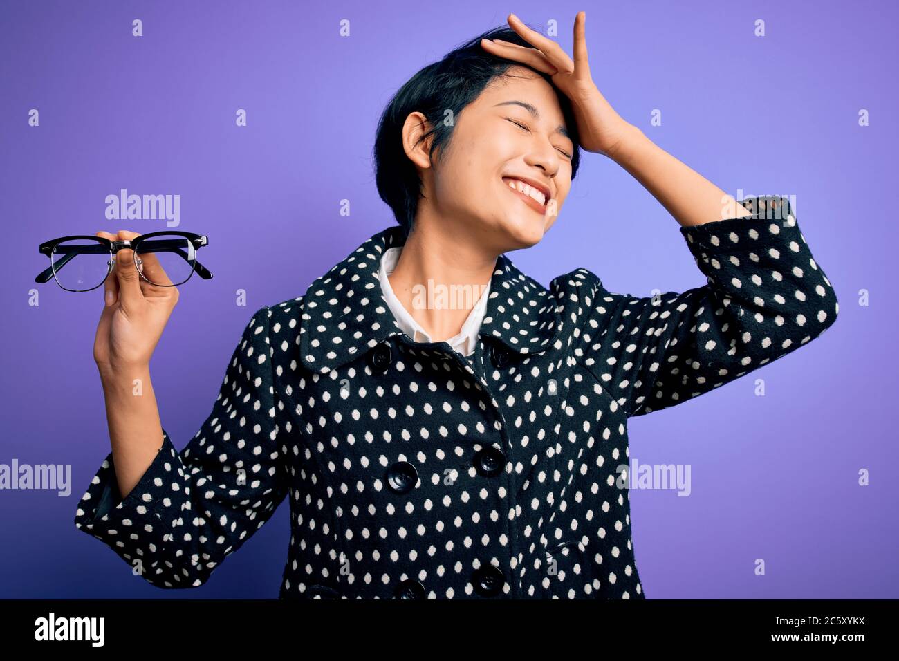 Young beautiful asian optical girl holding vision glasses over isolated ...