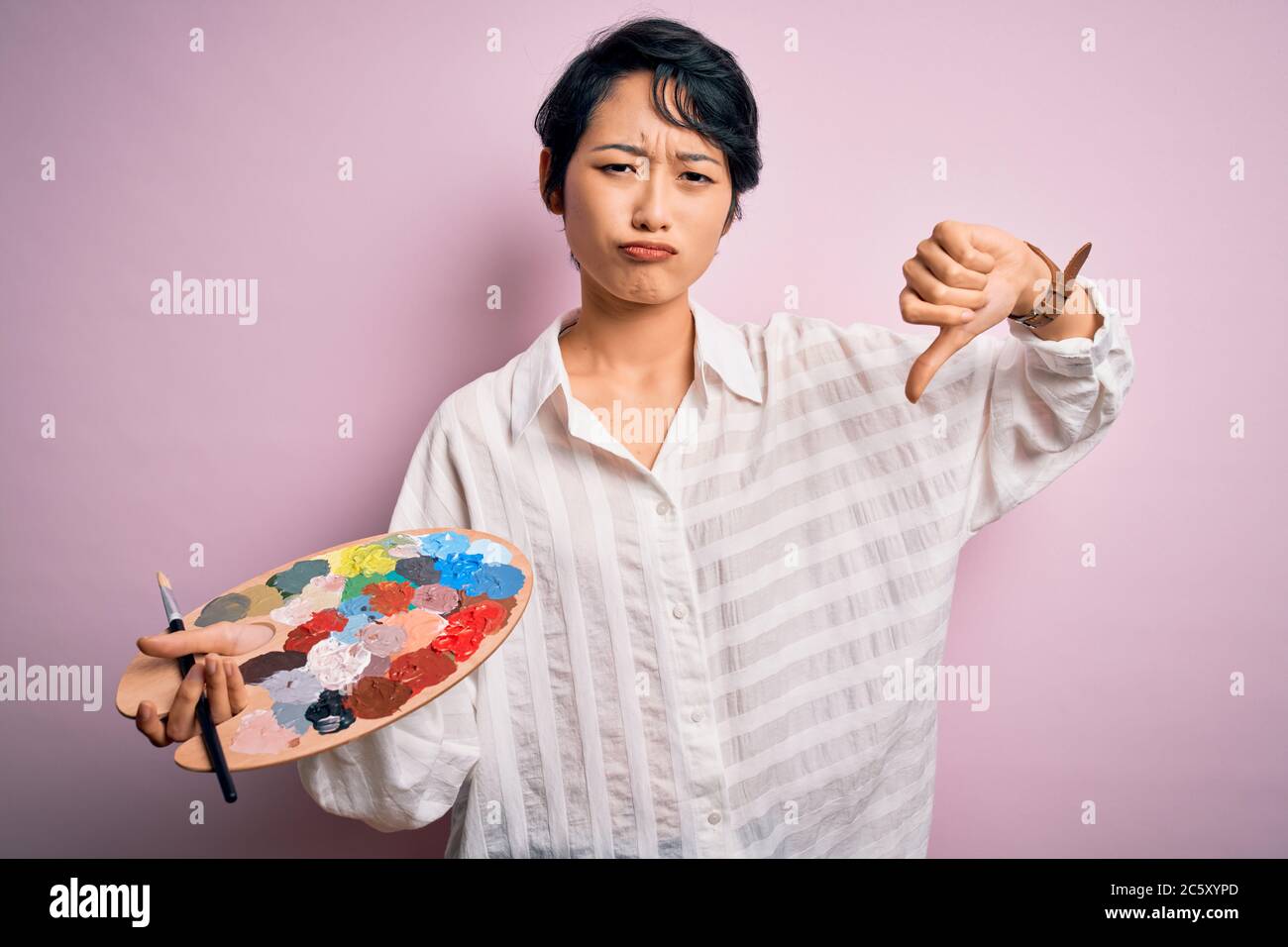 Young beautiful chinese artist woman painting using paintbrush and ...