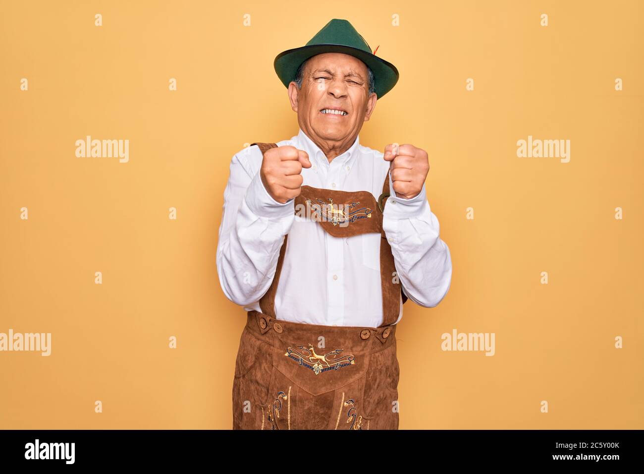 Senior grey-haired man wearing german traditional octoberfest suit over ...