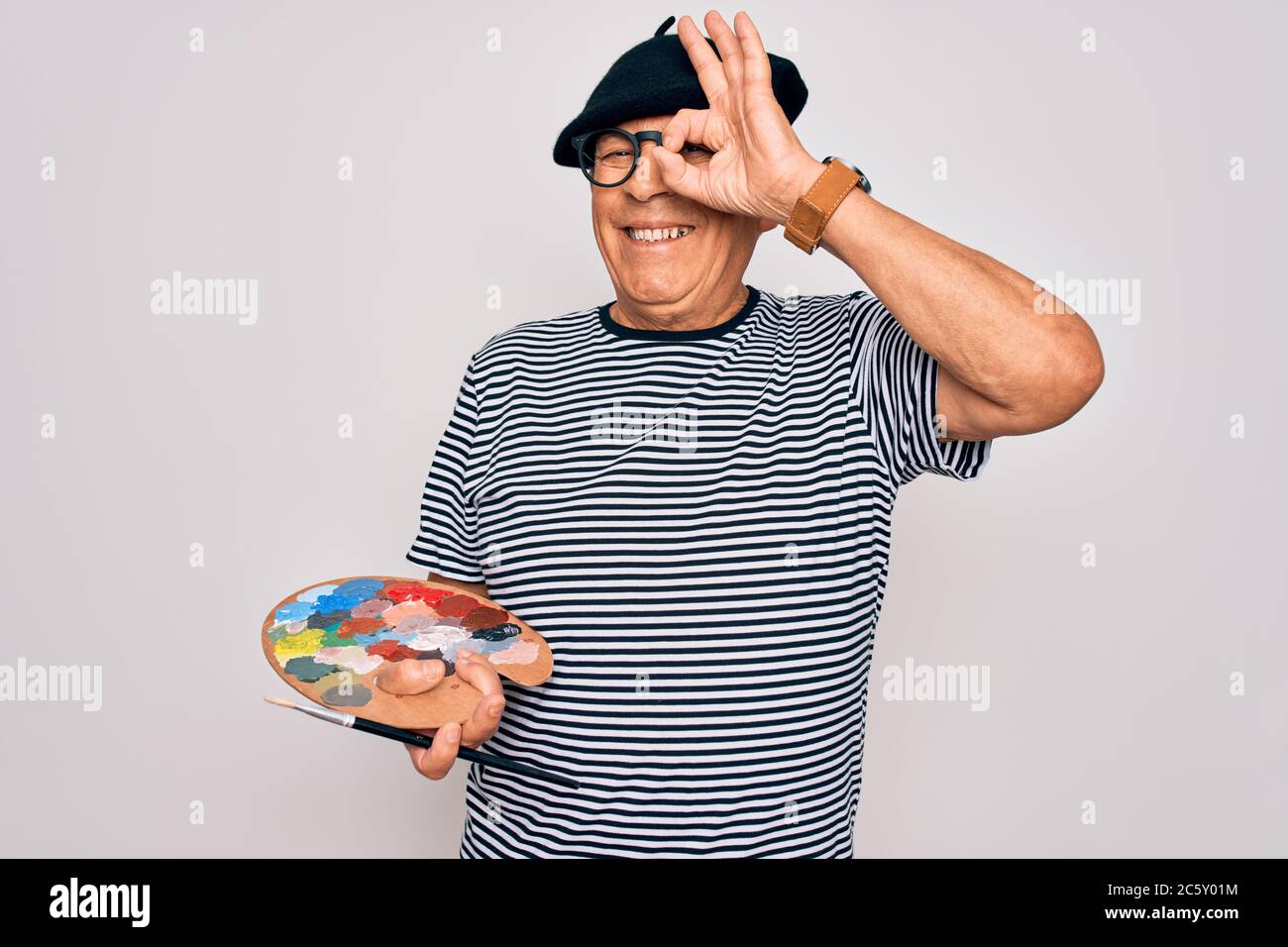 Senior hoary artist man wearing french beret drawing using paintbrush ...