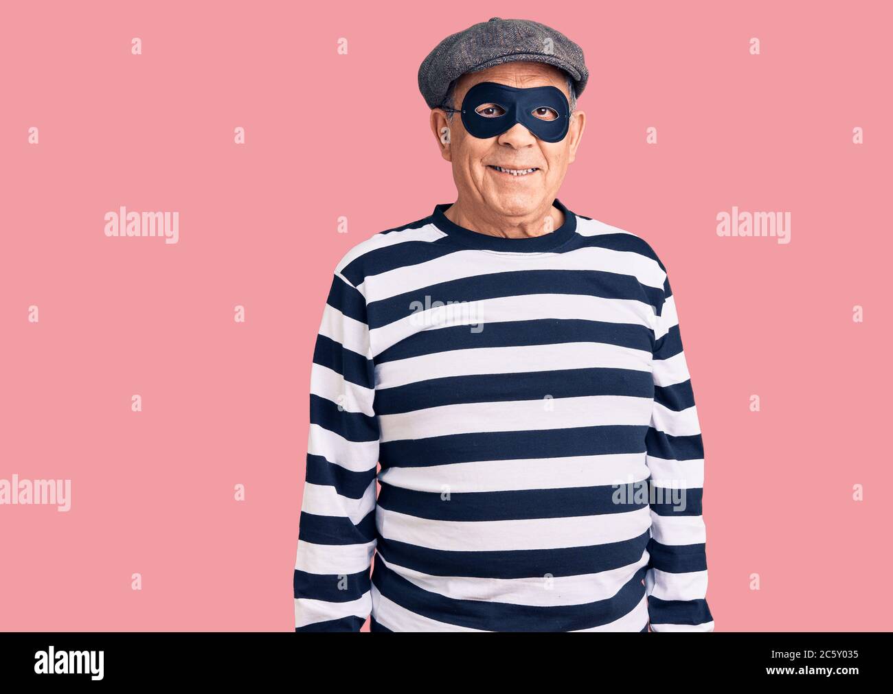 Senior handsome man wearing burglar mask and t-shirt with a happy and ...
