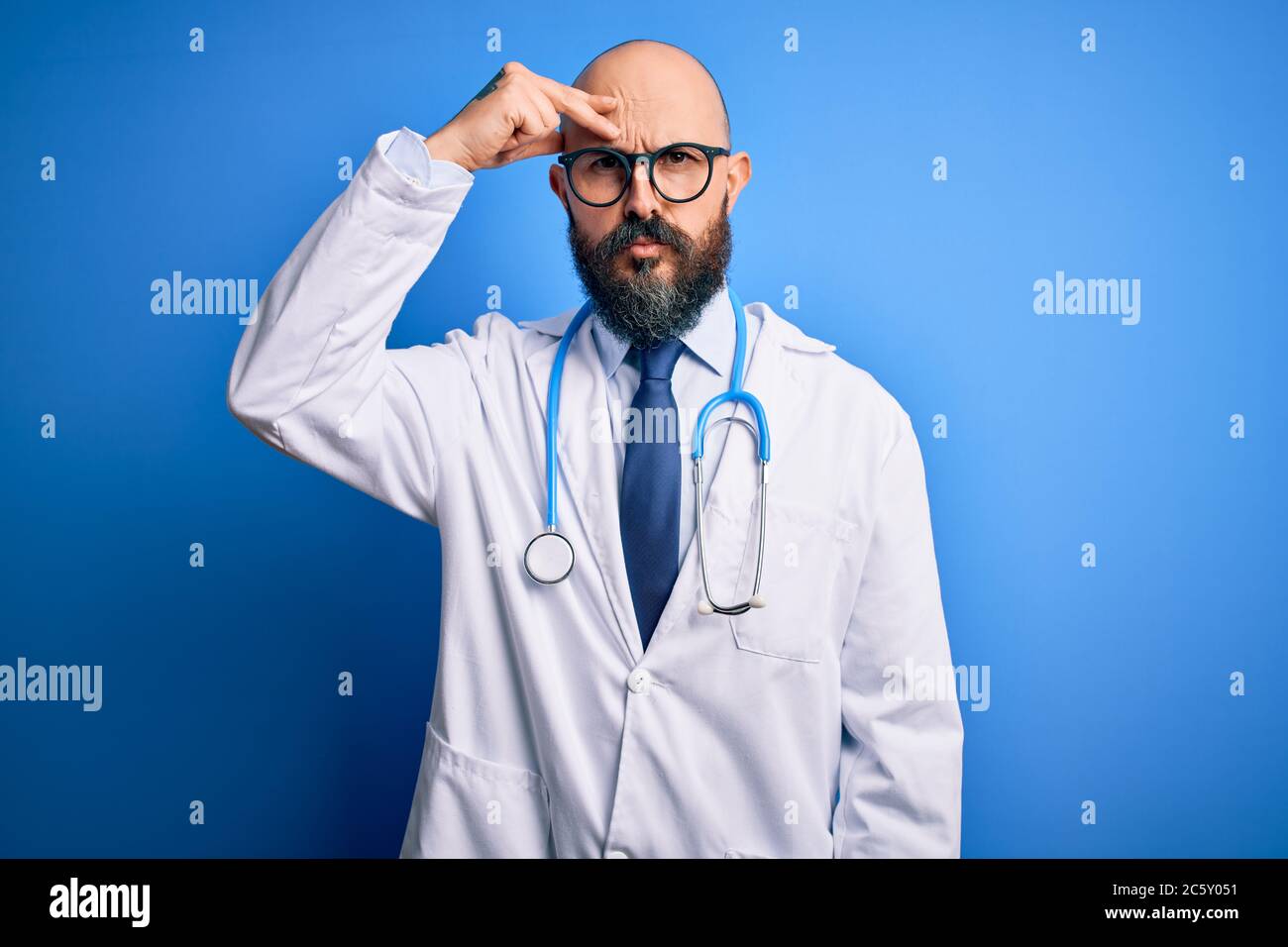 Handsome bald doctor man with beard wearing glasses and stethoscope ...