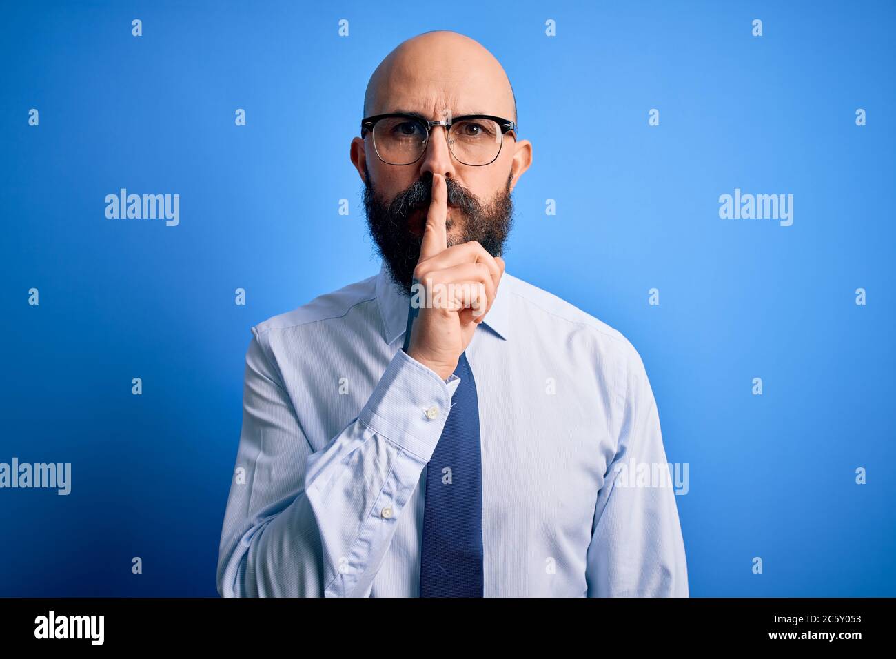 Handsome business bald man with beard wearing elegant tie and glasses ...