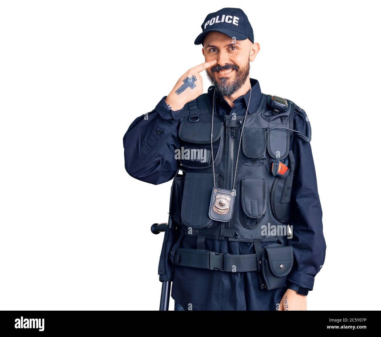 Young handsome man wearing police uniform pointing with hand finger to ...