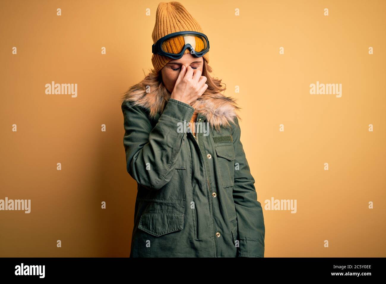 Middle age beautiful blonde skier woman wearing snow sportwear and ski ...