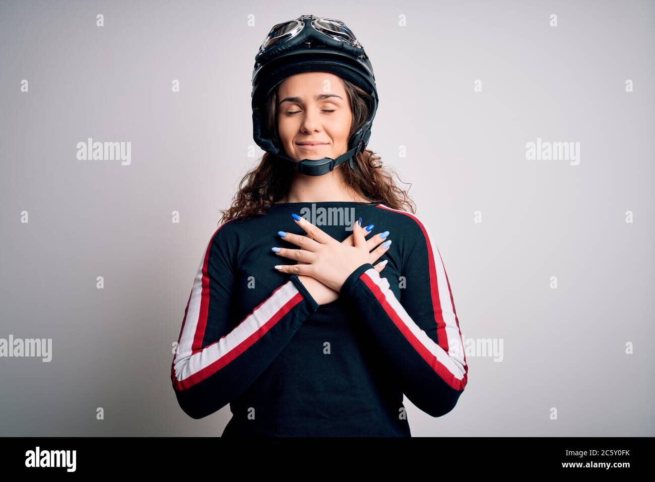 Beautiful motorcyclist woman with curly hair wearing moto helmet over ...