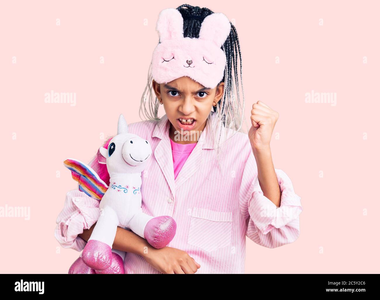 Cute african american girl wearing sleep mask and pajama holding pink ...