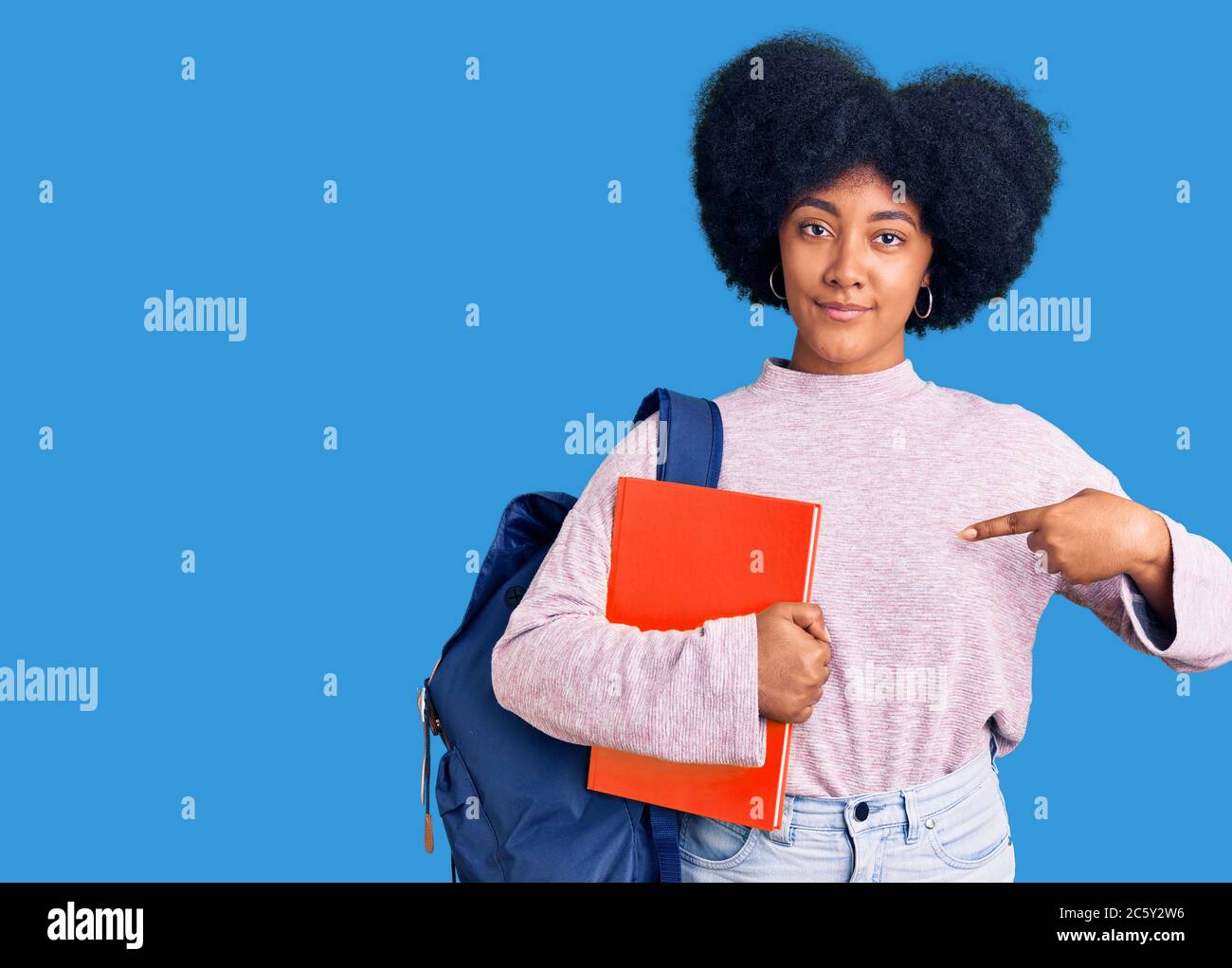 Young african american girl wearing student backpack holding book ...