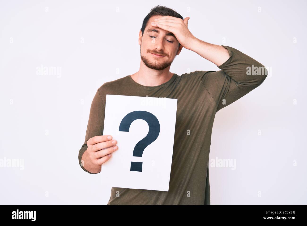 Young handsome man holding question mark stressed and frustrated with ...
