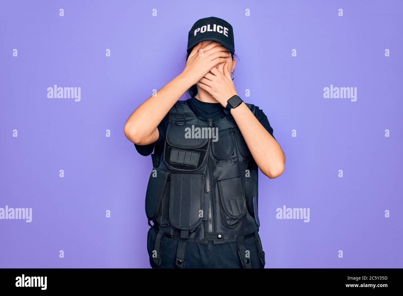 Young police woman wearing security bulletproof vest uniform over ...