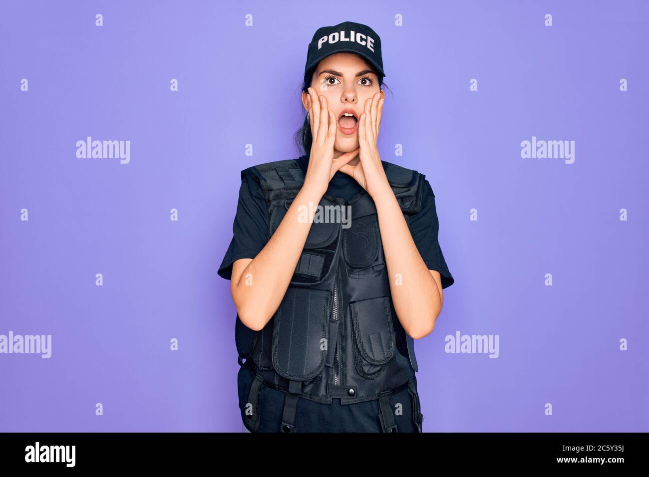 Young police woman wearing security bulletproof vest uniform over ...