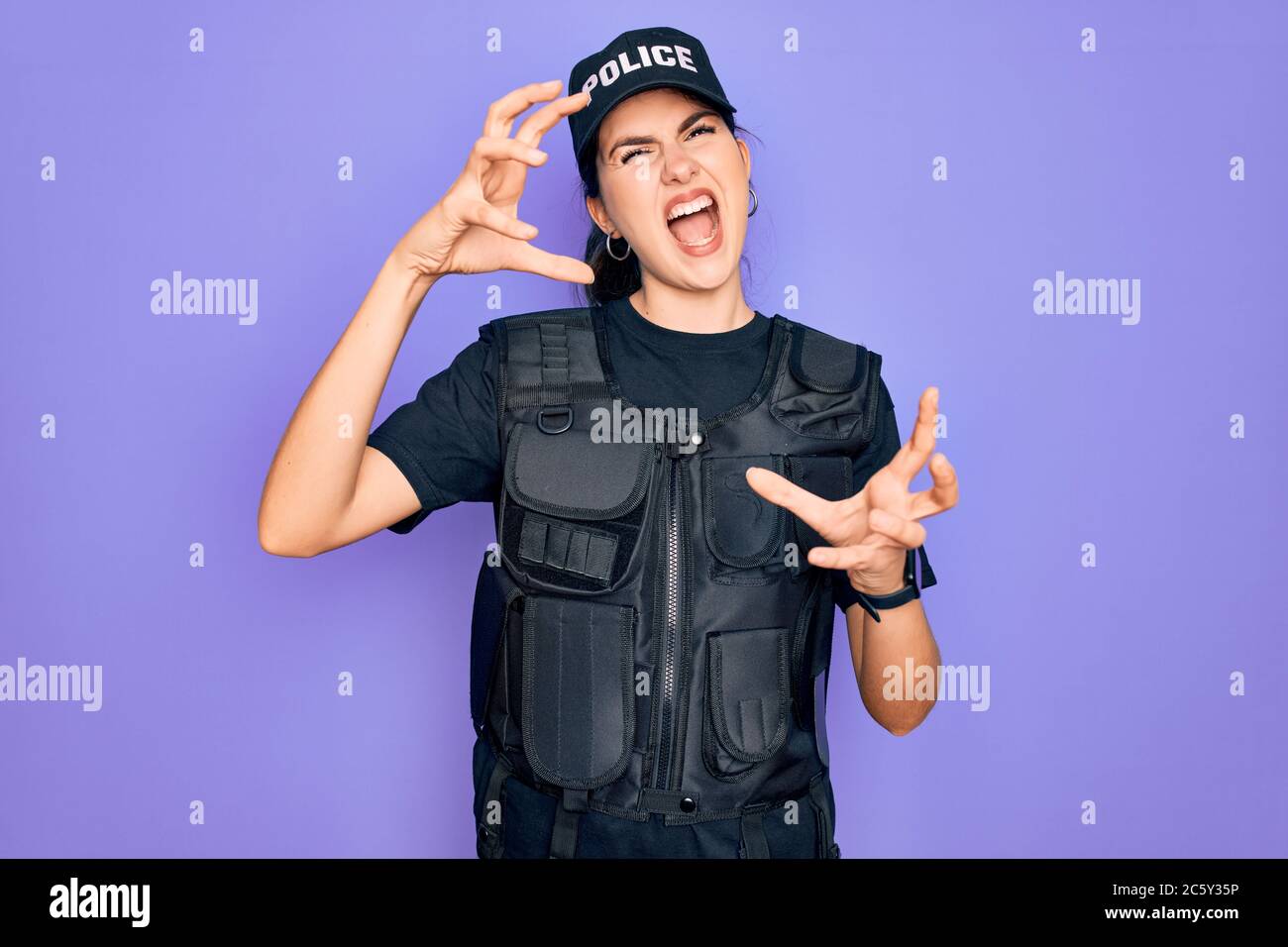 Young police woman wearing security bulletproof vest uniform over ...