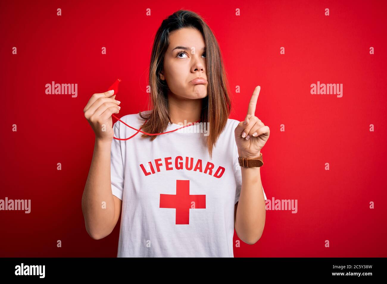 Young beautiful brunette lifeguard girl wearing t-shirt with red cross ...