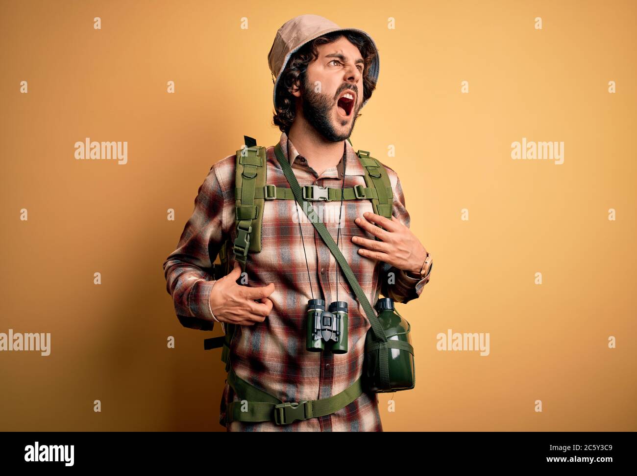 Young hiker man with curly hair and beard hiking wearing backpack and ...