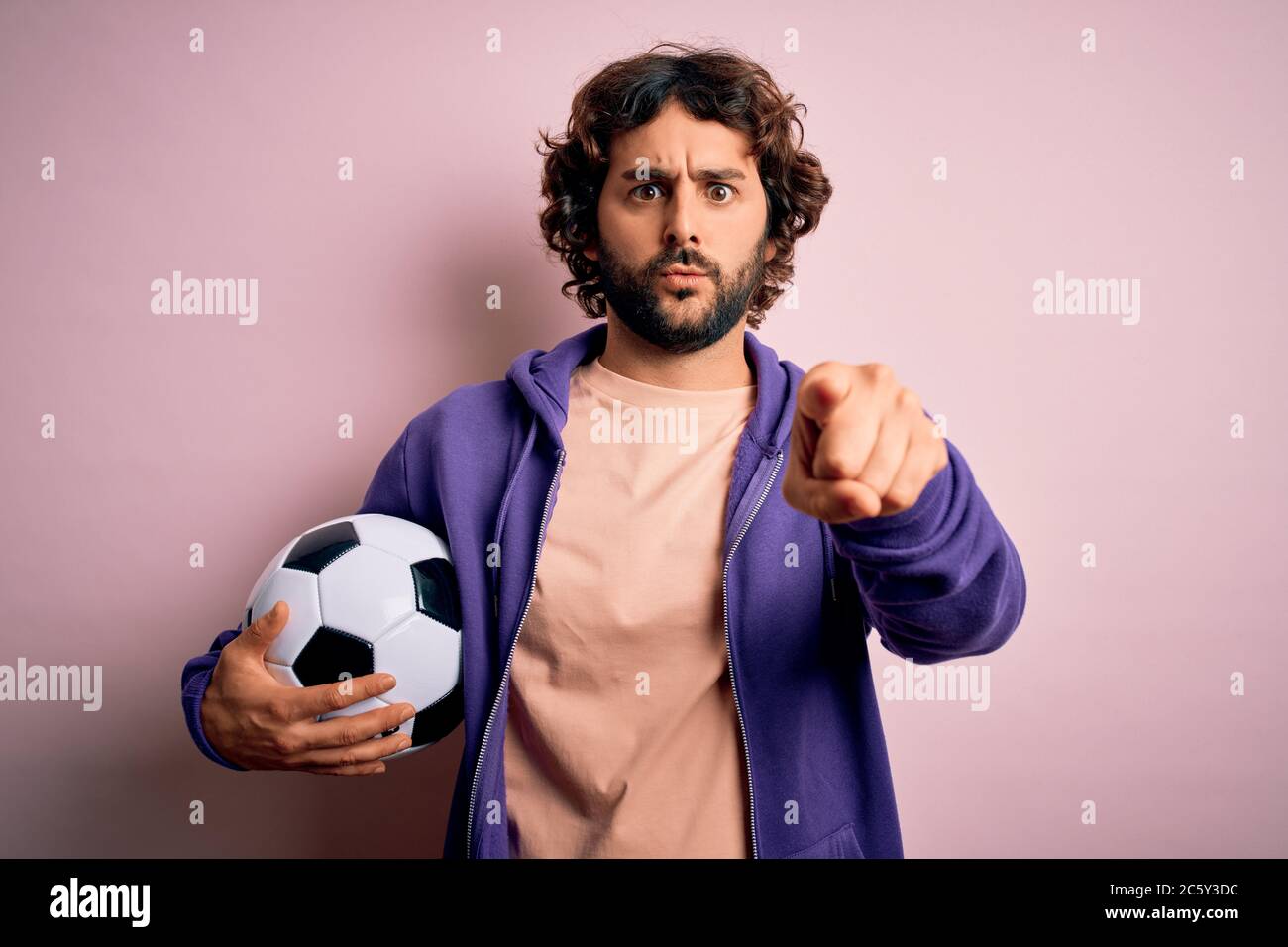 Handsome player man with beard playing soccer holding football ball ...