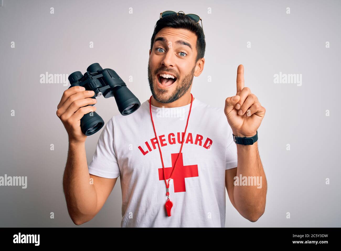 Young lifeguard man with beard wearing t-shirt with red cross and ...