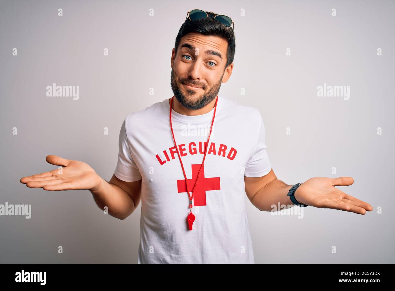 Young handsome lifeguard man with beard wearing t-shirt with red cross ...